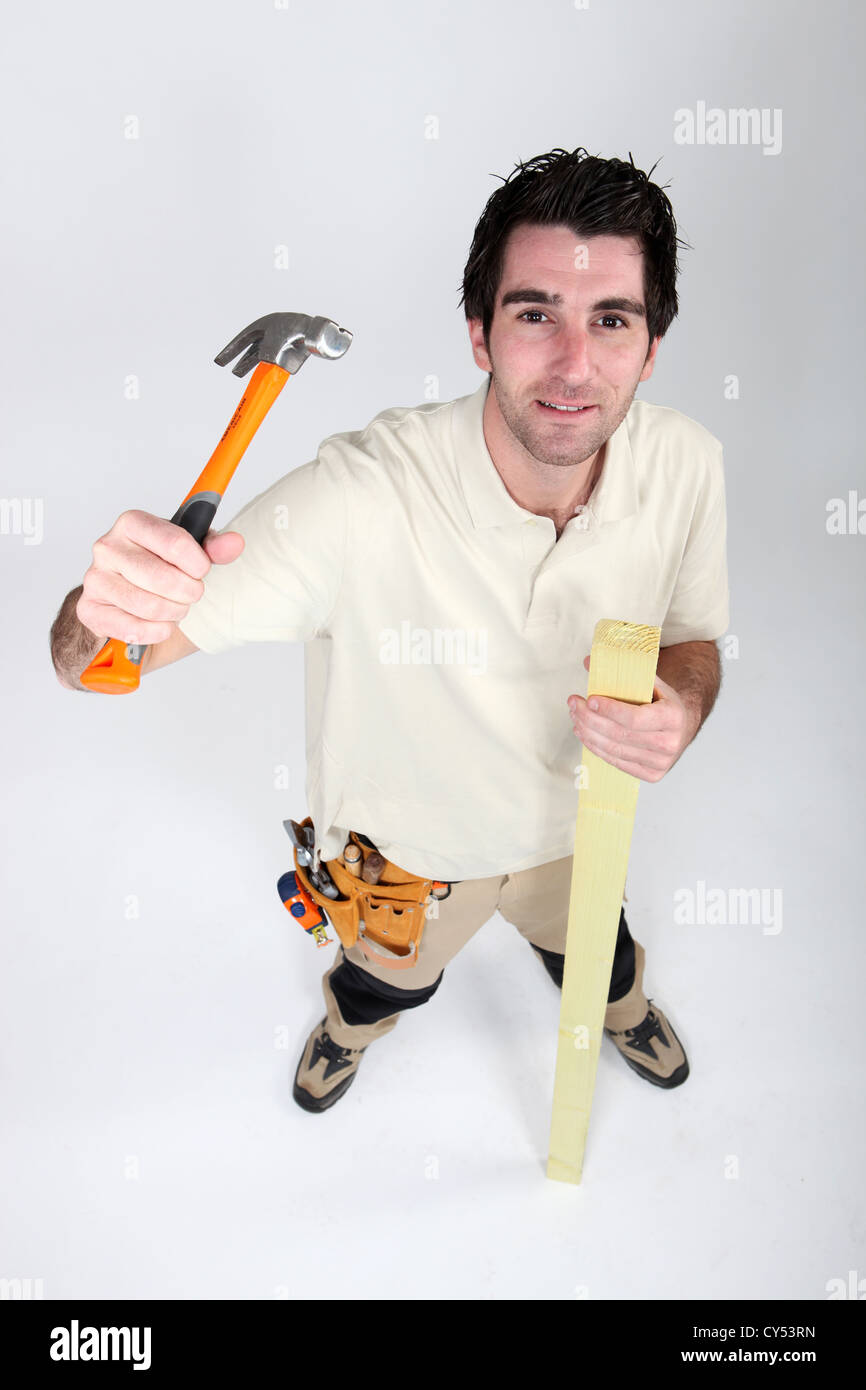 craftsman holding a wooden board and a hammer Stock Photo - Alamy