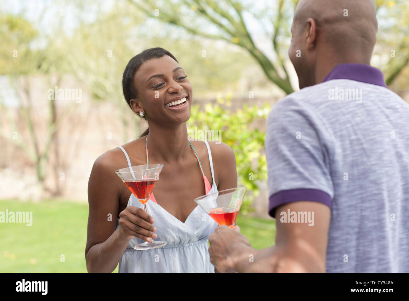 African American couple socializing around pool Stock Photo - Alamy