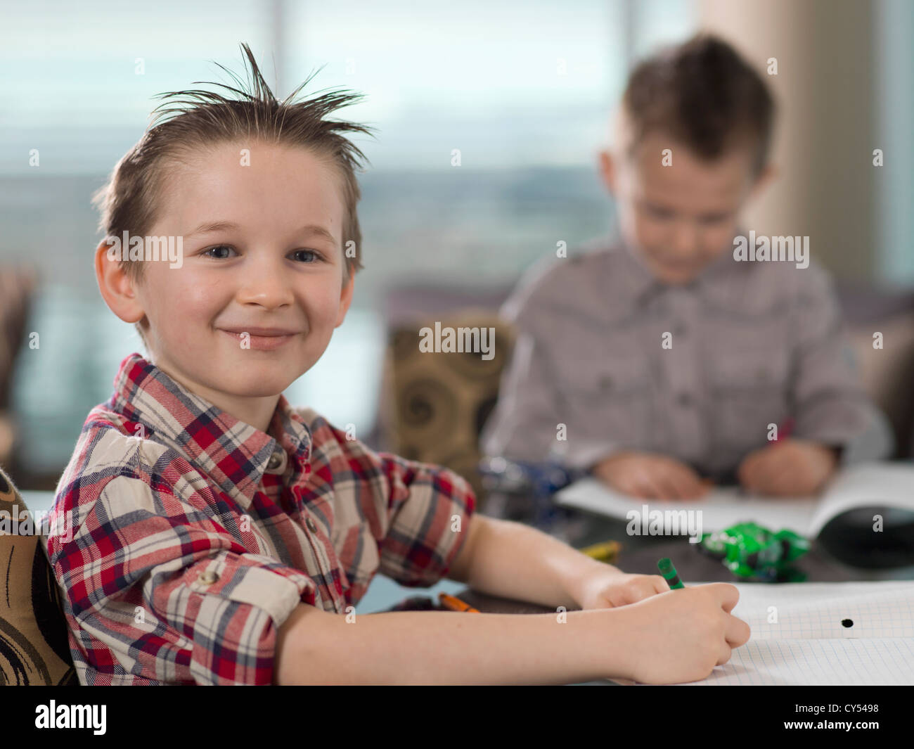 Young boys (6-7) doing homework at kitchen table Stock Photo - Alamy