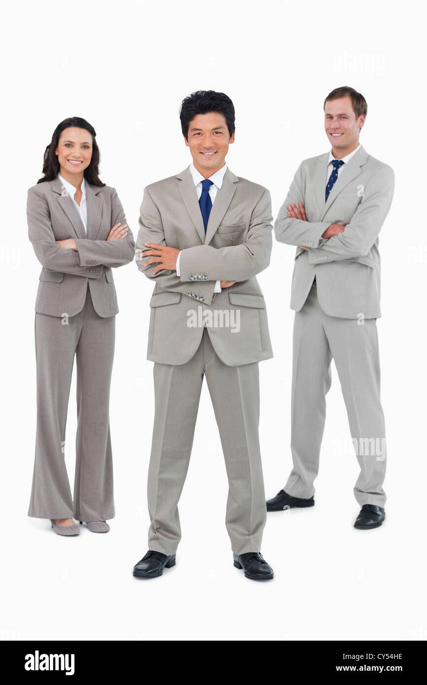 Smiling sales team with folded arms Stock Photo - Alamy