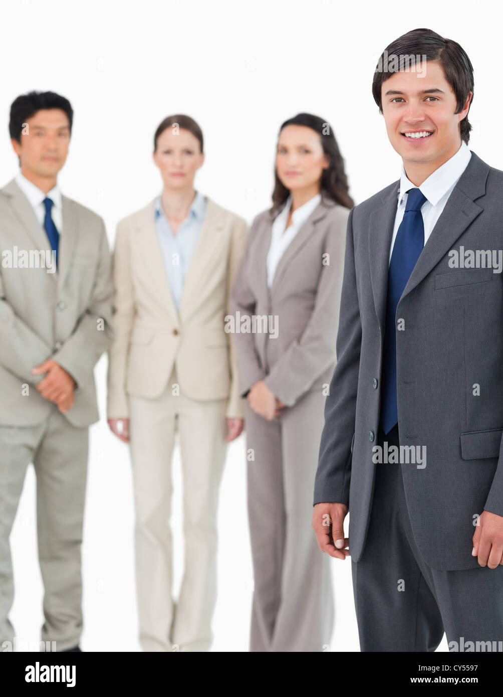 Smiling young salesman with his team behind him Stock Photo - Alamy