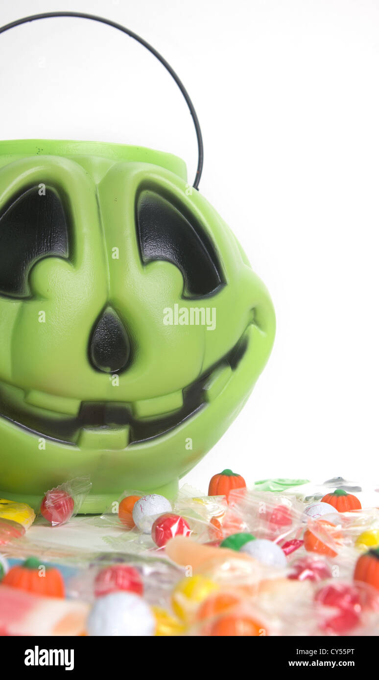 Green pumpkin Halloween bucket filled with candy, candy corn, suckers ...