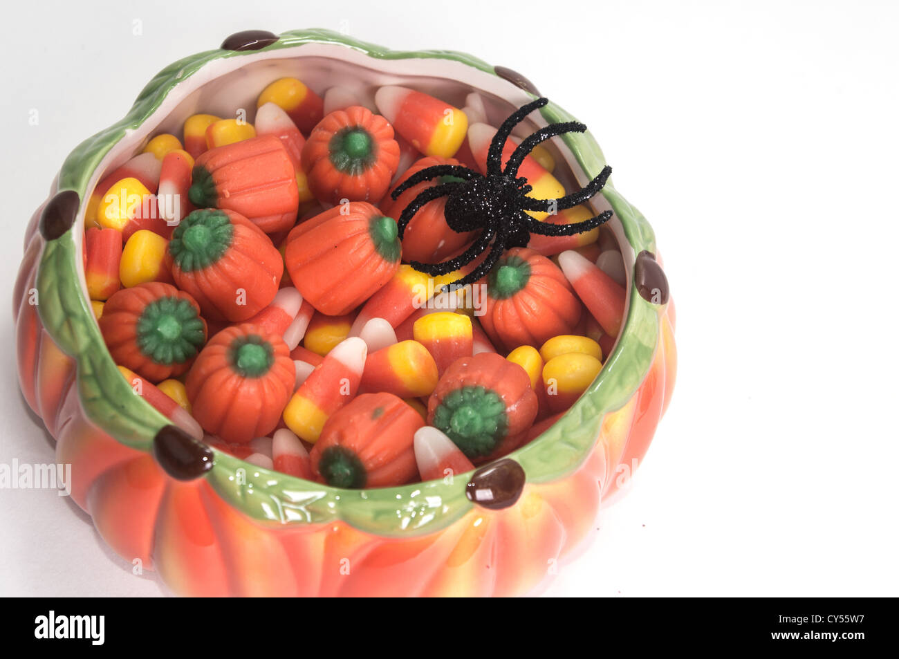 Candy corn in Halloween dish with black toy spider Stock Photo - Alamy