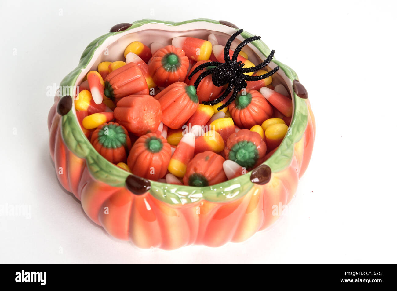 Candy corn in Halloween dish with black toy spider Stock Photo - Alamy