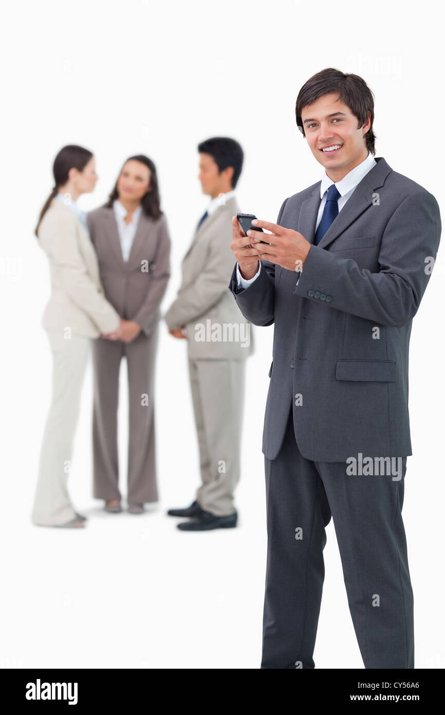 Smiling tradesman with cellphone and colleagues behind him Stock Photo ...