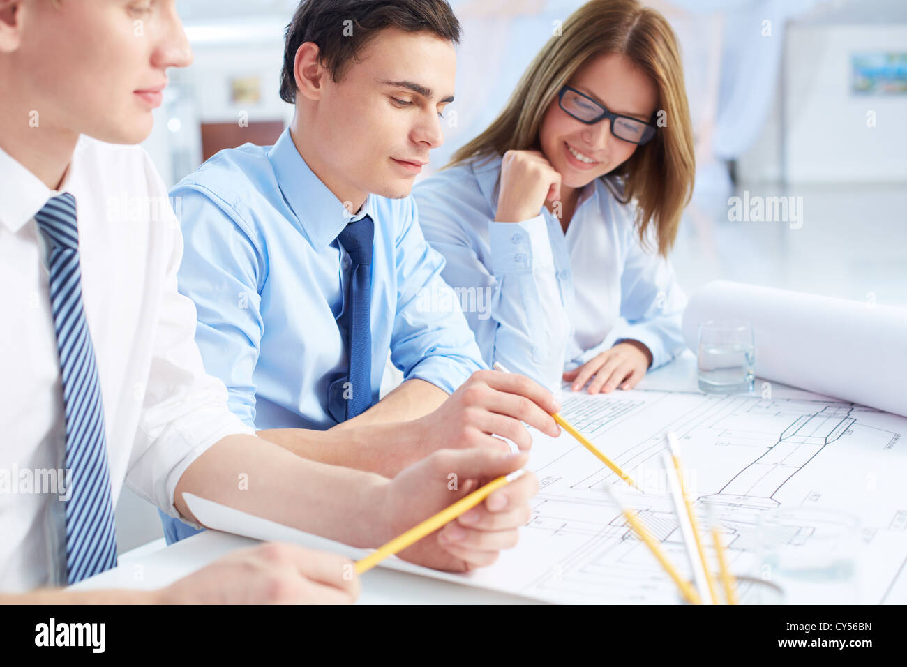 Team of engineers discussing blueprint at meeting Stock Photo - Alamy
