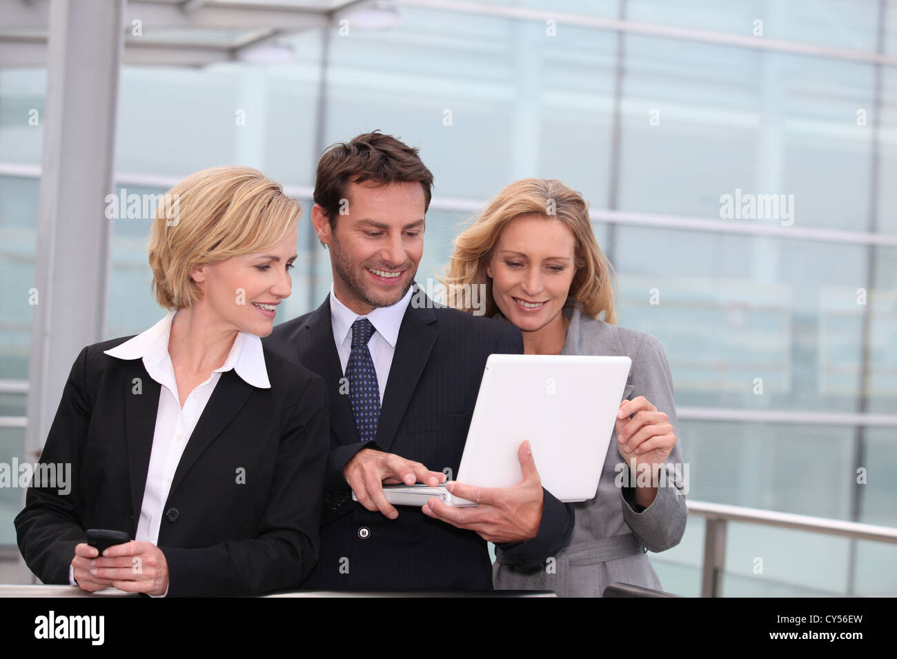 Business team looking at laptop Stock Photo - Alamy