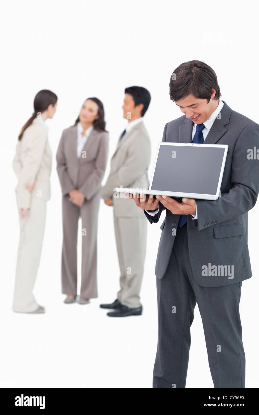 Salesman showing notebook screen with team behind him Stock Photo - Alamy
