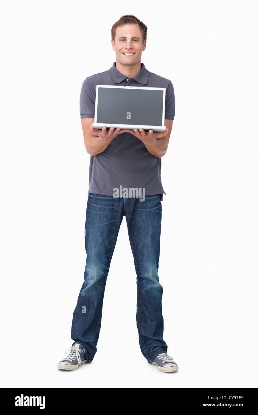 Smiling young man showing his laptop screen Stock Photo - Alamy