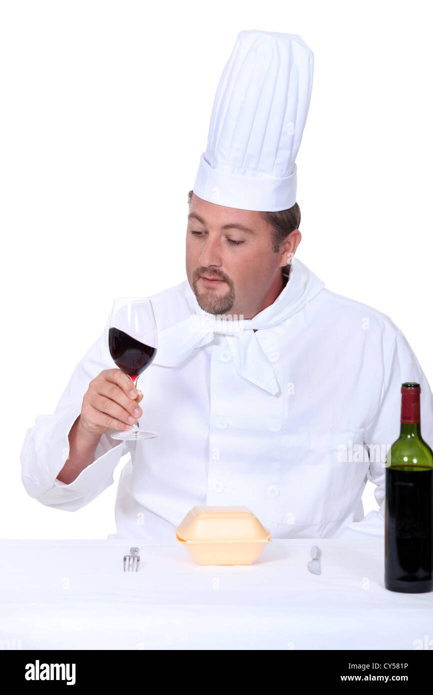 Chef with a glass of red wine and box of junk food Stock Photo - Alamy