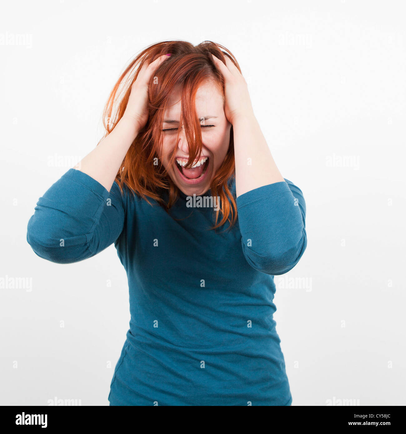 Studio shot, Portrait of woman holding her head and screaming Stock ...