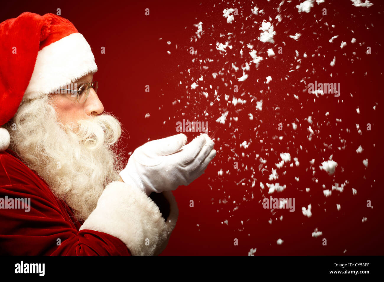 Photo of Santa Claus blowing snow and looking at it Stock Photo - Alamy