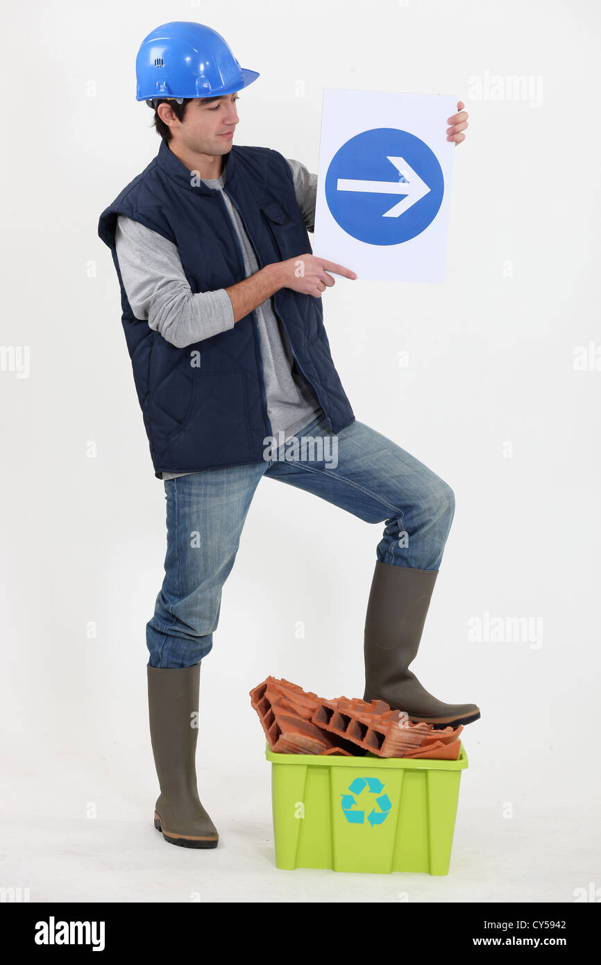 Labourer holding a traffic sign Stock Photo - Alamy
