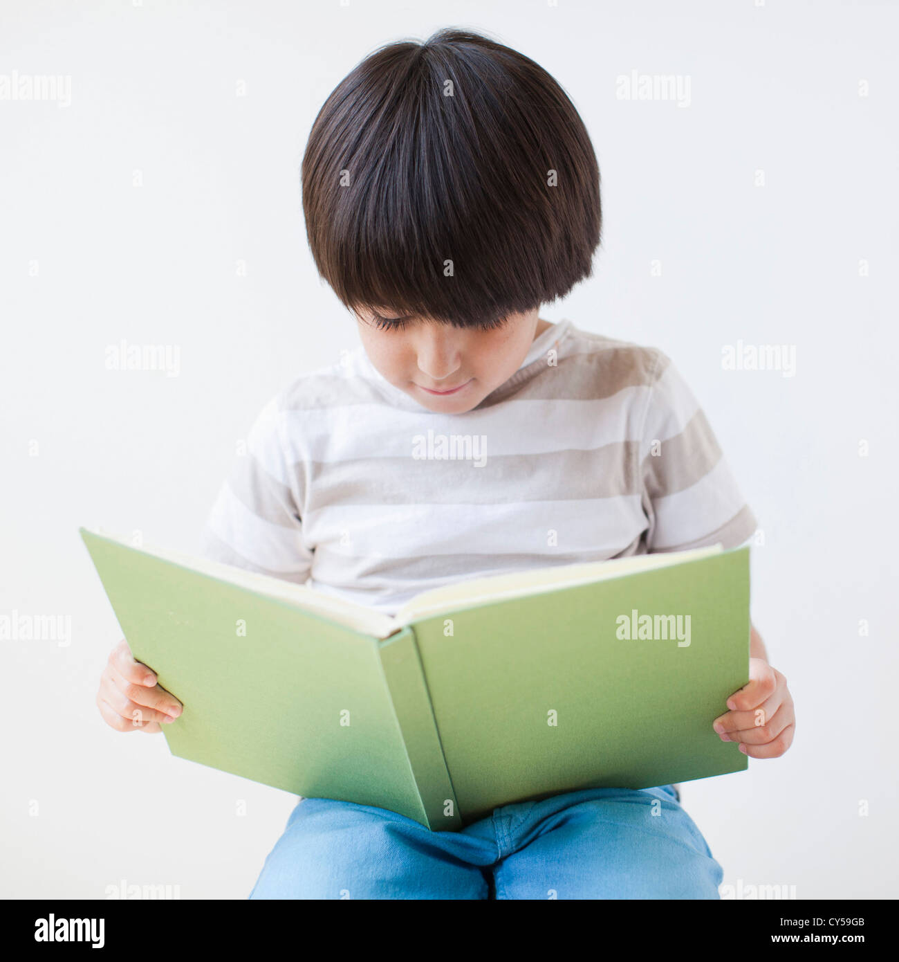 Studio Shot of young boy reading book Stock Photo - Alamy