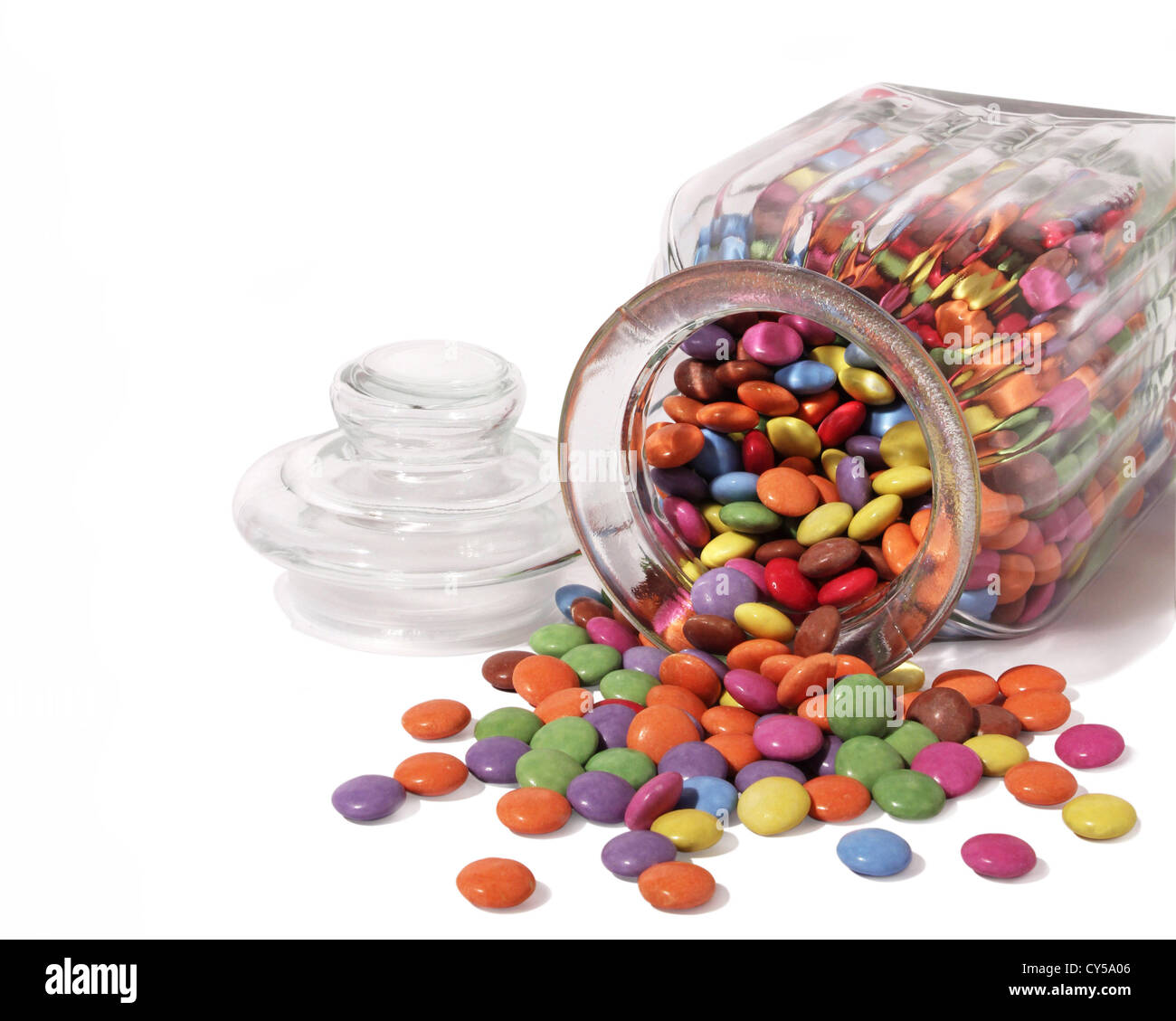 a tradtional sweet jar with sweets spilling out. On a white background ...