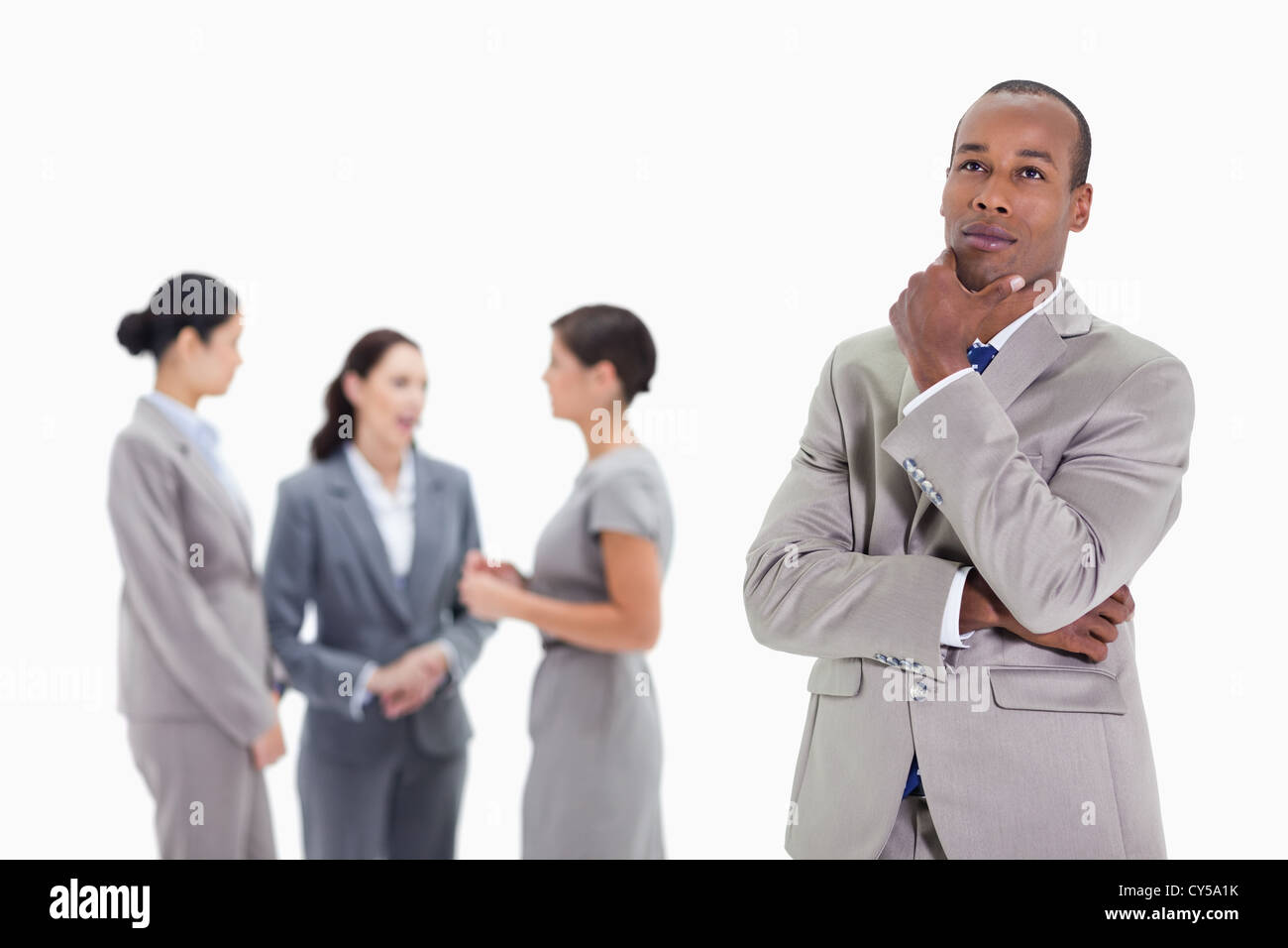 Thoughtful businessman looking up with co-workers behind him Stock ...