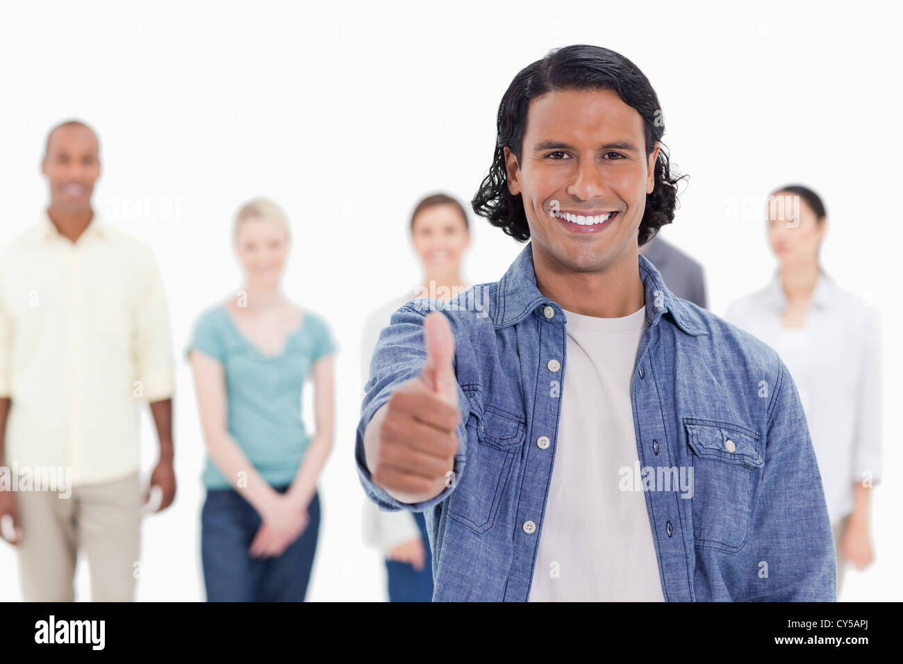 Man with his thumb-up with people behind him Stock Photo - Alamy