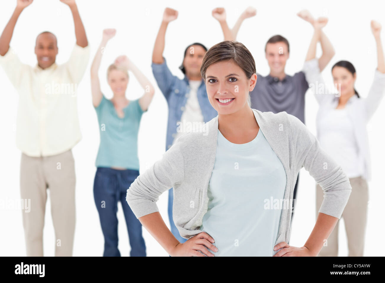Woman smiling with people behind her raising their arms Stock Photo - Alamy