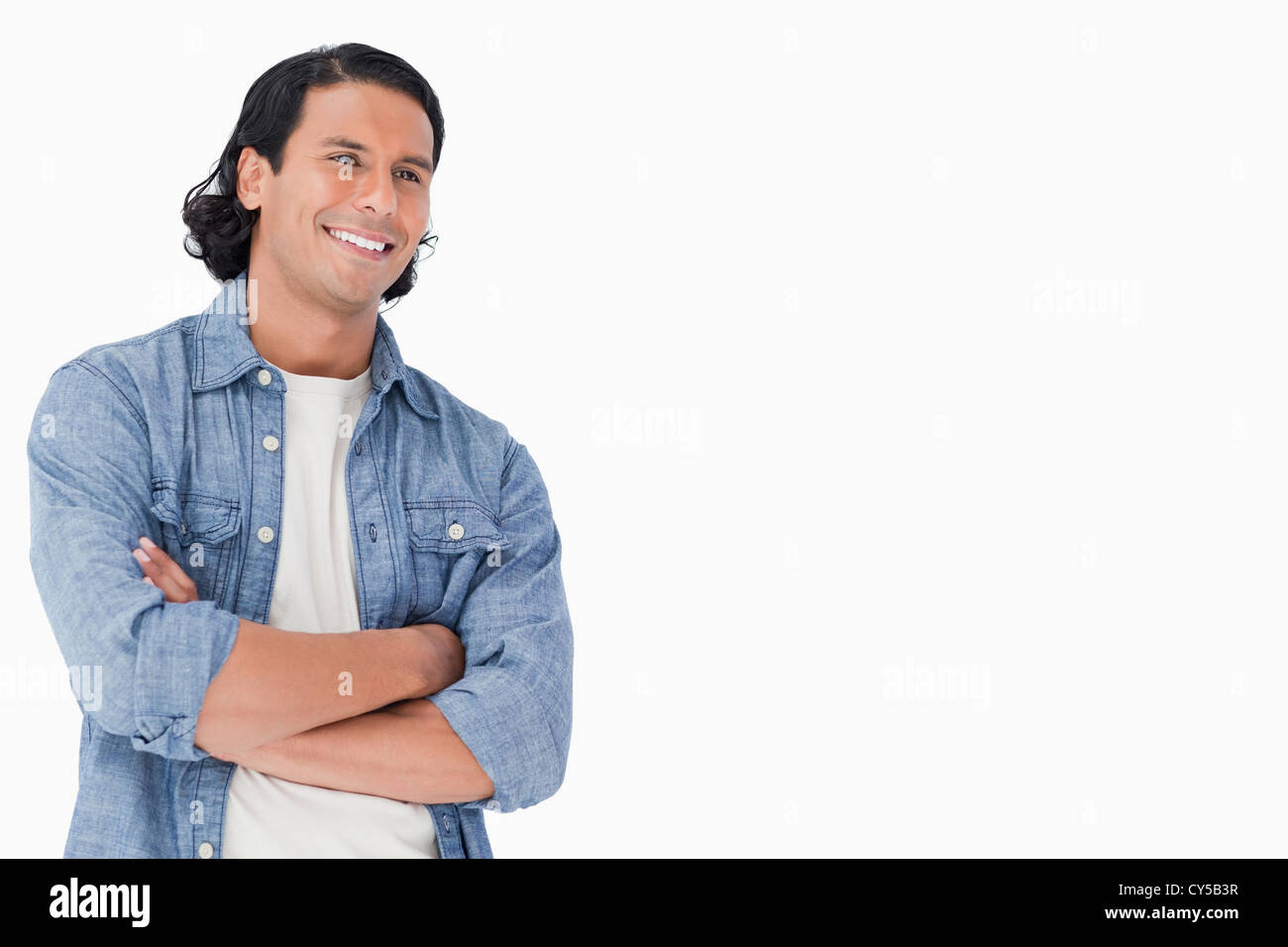 A smiling man crossing his arms and looking away Stock Photo - Alamy