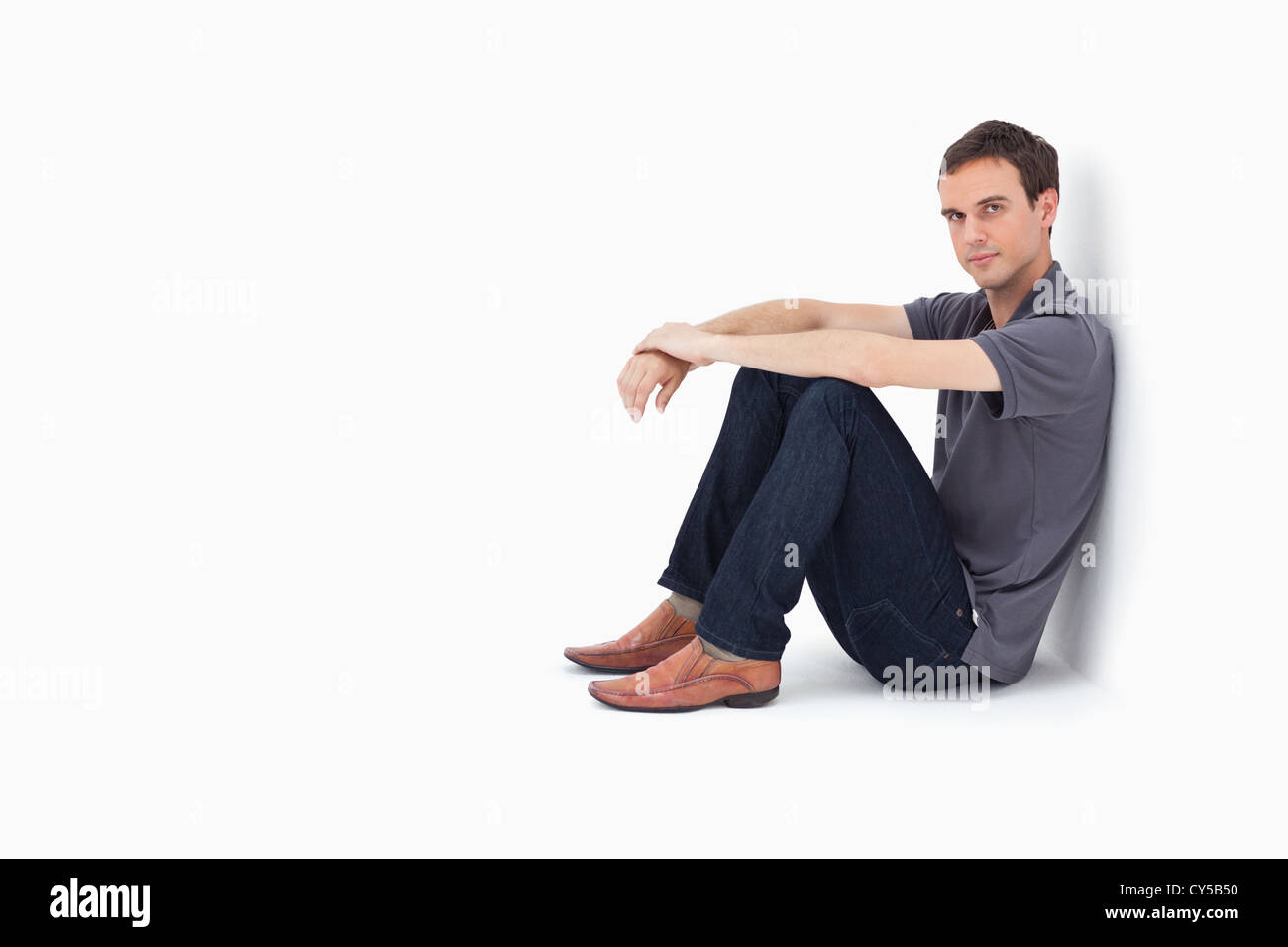 Young man sitting against Cut Out Stock Images & Pictures - Alamy