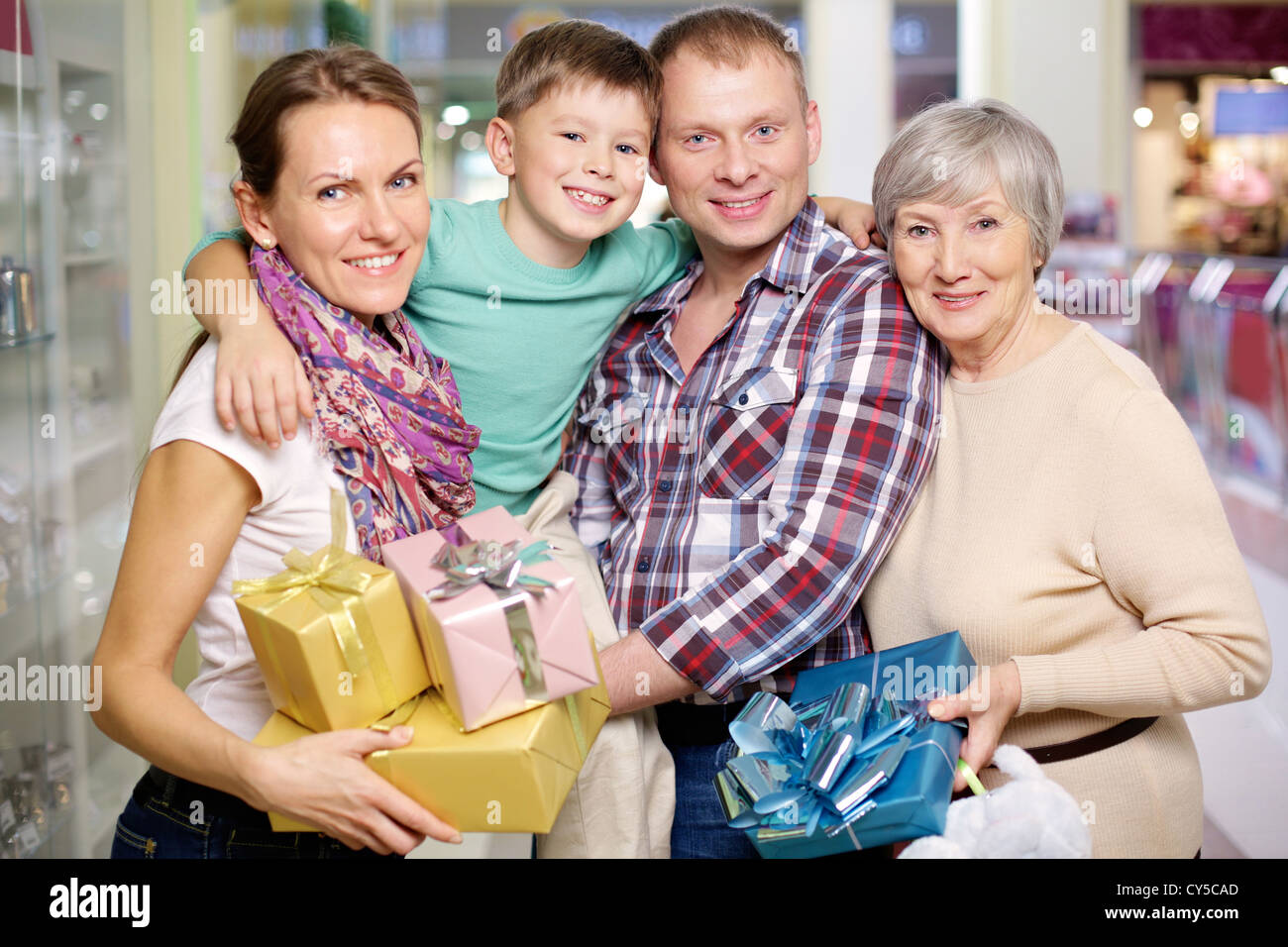 Portrait of family holding giftboxes in the shop Stock Photo - Alamy