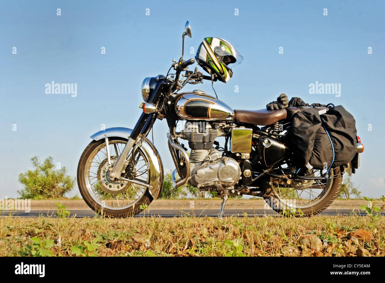 Retro style motorcycle parked in a generic highway road rural scene ...