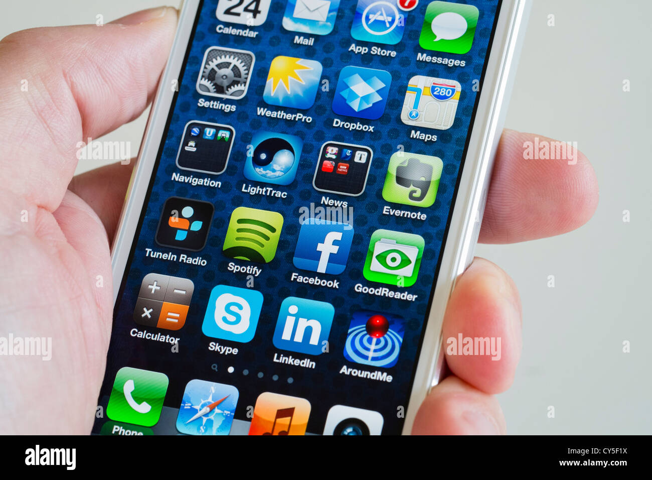 Close-up detail of man holding new iPhone 5 smart phone showing screen ...