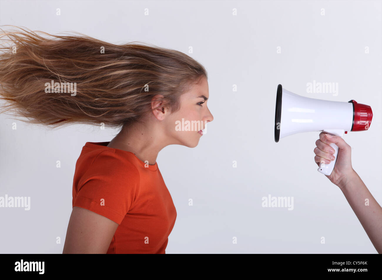 Girl with hair blown backwards by megaphone Stock Photo - Alamy