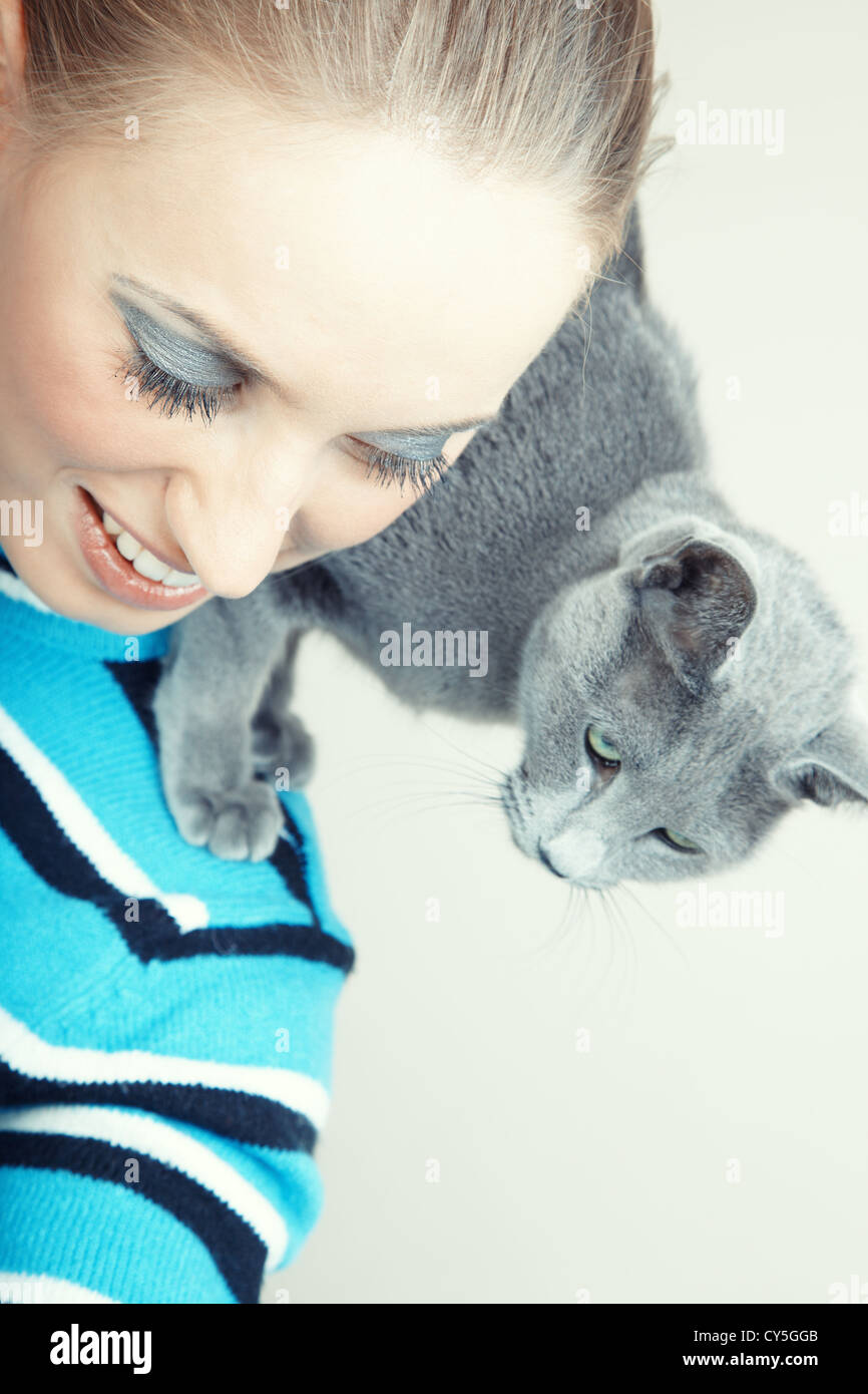 Smiling lady pampering her cat indoors. Natural light and colors Stock ...