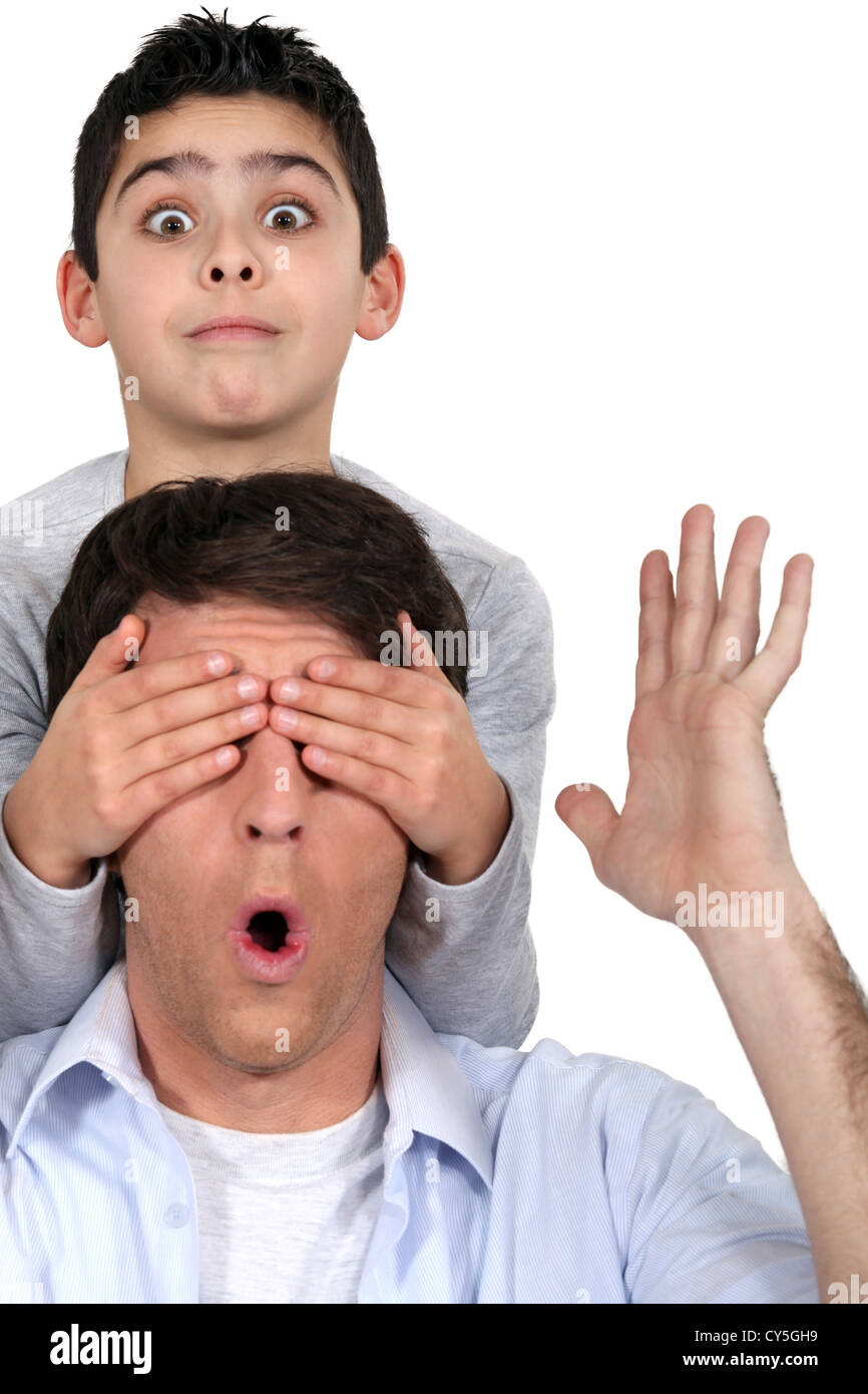 Boy covering his dad's eyes Stock Photo - Alamy