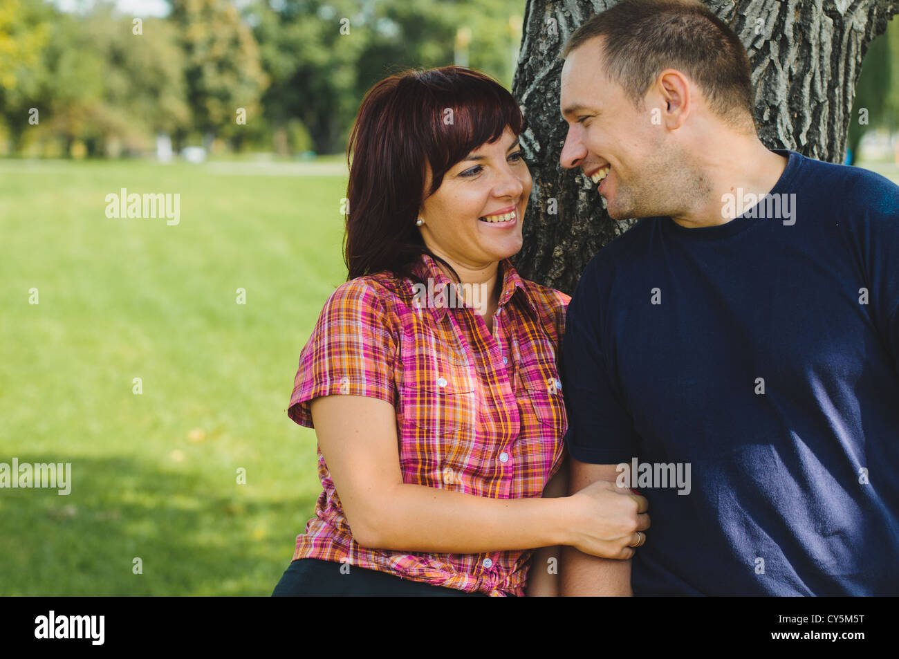 Good looking couple in love smiles each other outdoor Stock Photo - Alamy