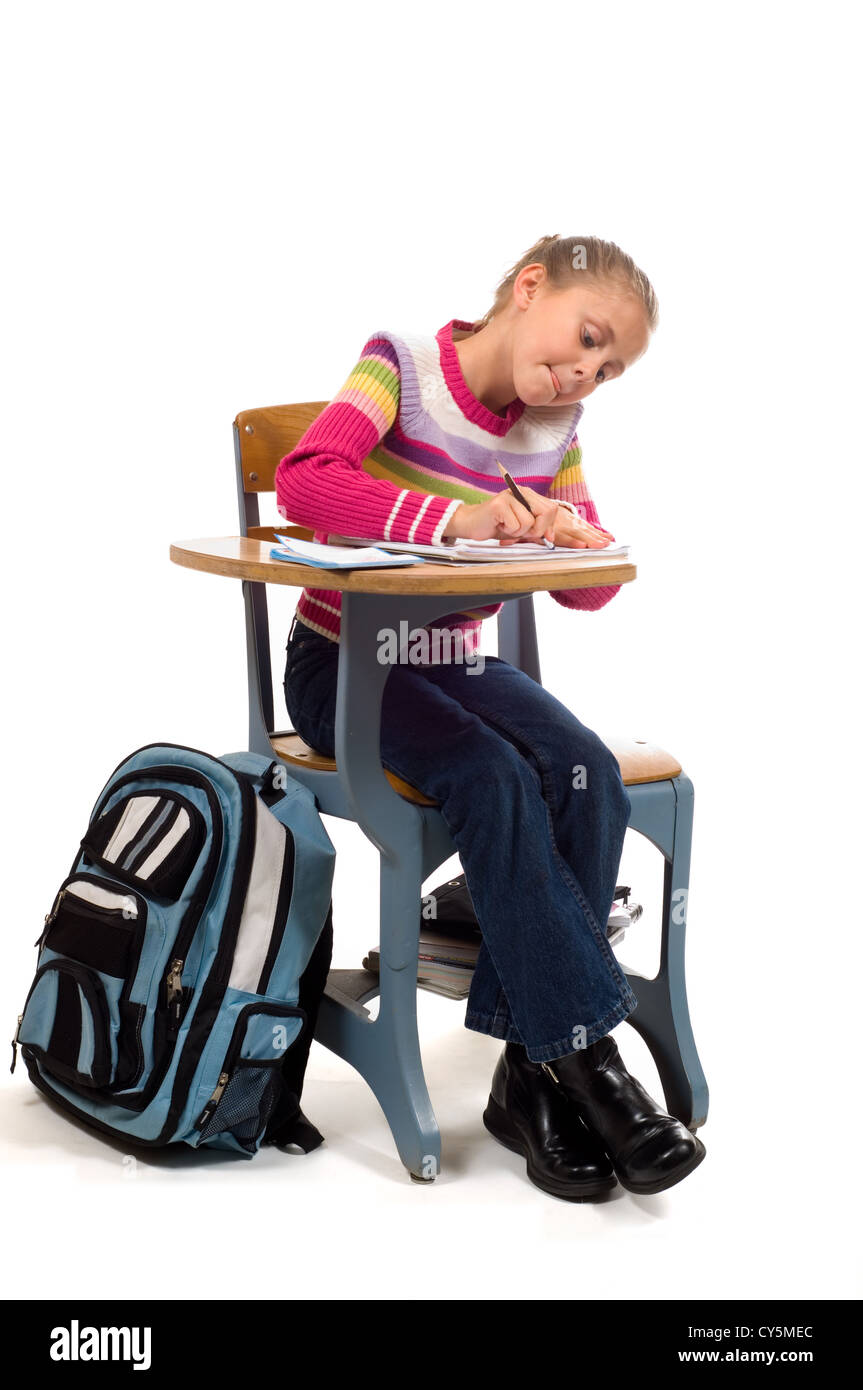 young girl concentrating on work, correcting mistake, erasing at school ...