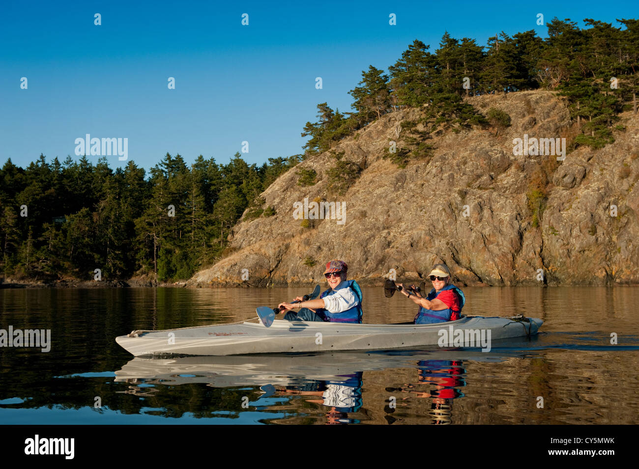 Two women kayak off of Shaw Island in the San Juan Islands of Puget ...