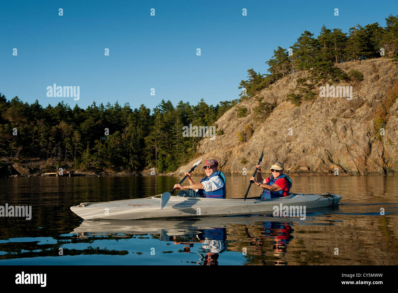Two women kayak off of Shaw Island in the San Juan Islands of Puget ...