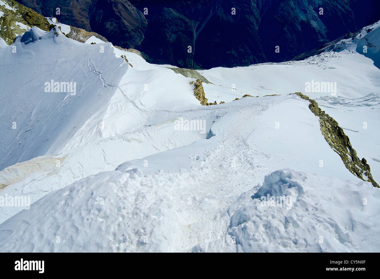 Summit view of narrow snow path on high mountain in the Swiss Alps ...