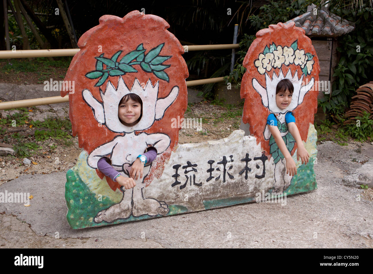 Two children pose as Kijimuna. The Kijimuna are traditional Okinawan ...
