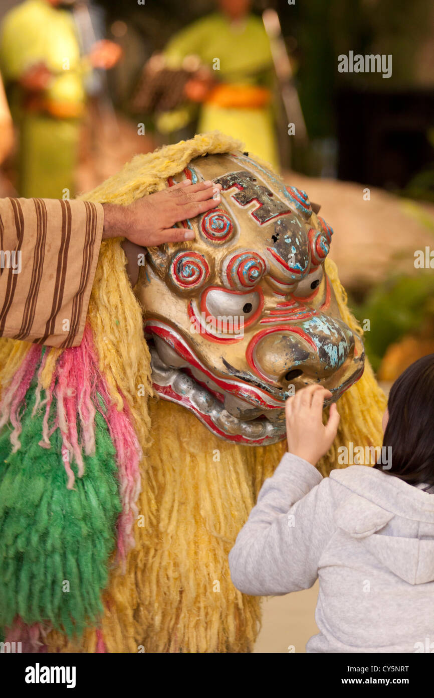 A lion god - Shiisa performs for visitors to Ryukyu Mura - a theme park ...