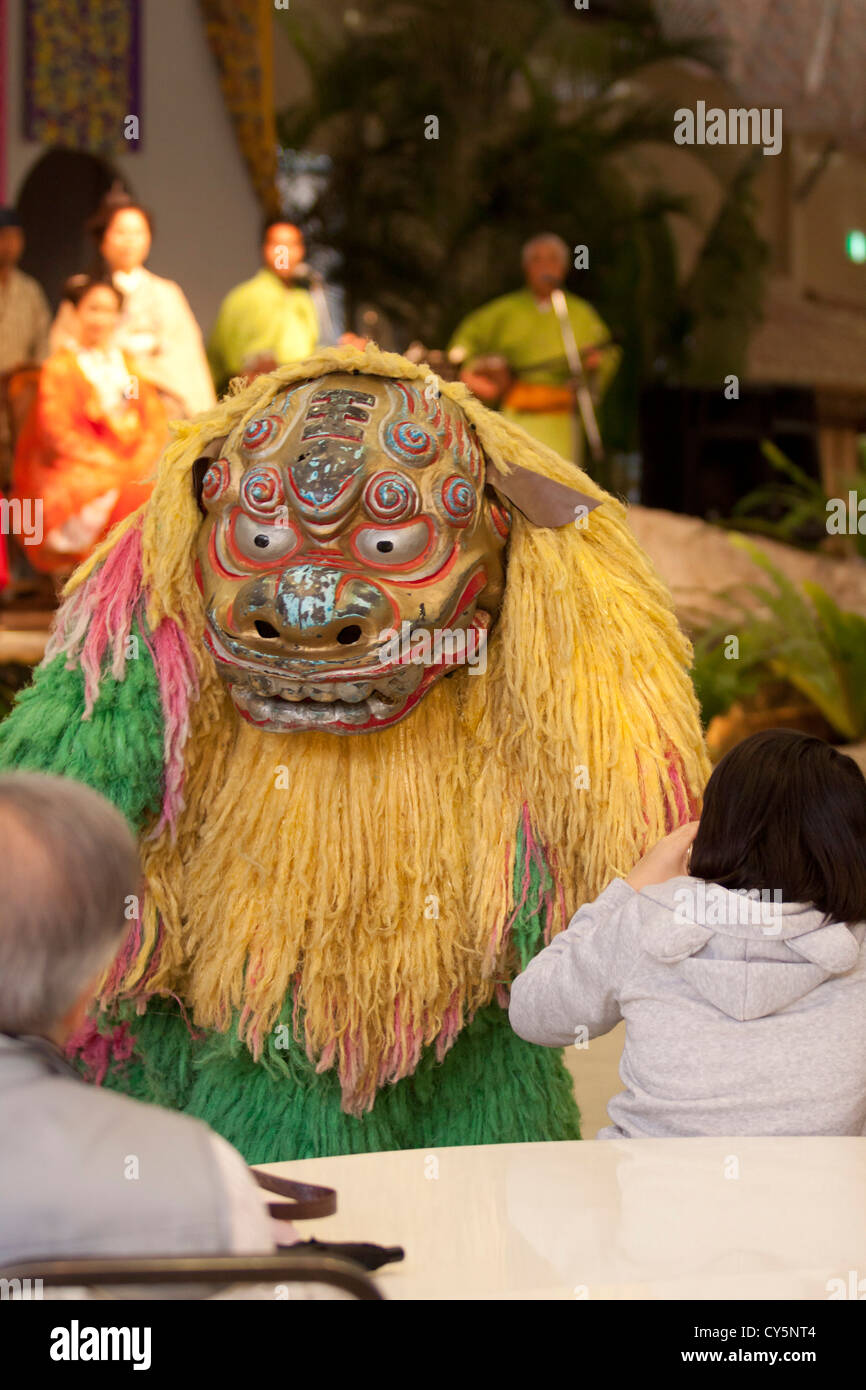 A lion god - Shiisa performs for visitors to Ryukyu Mura - a theme park ...