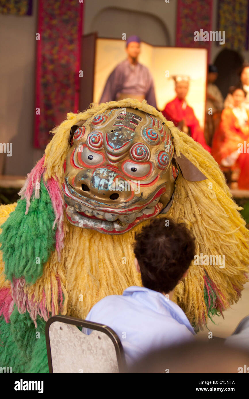 A lion god - Shiisa performs for visitors to Ryukyu Mura - a theme park ...
