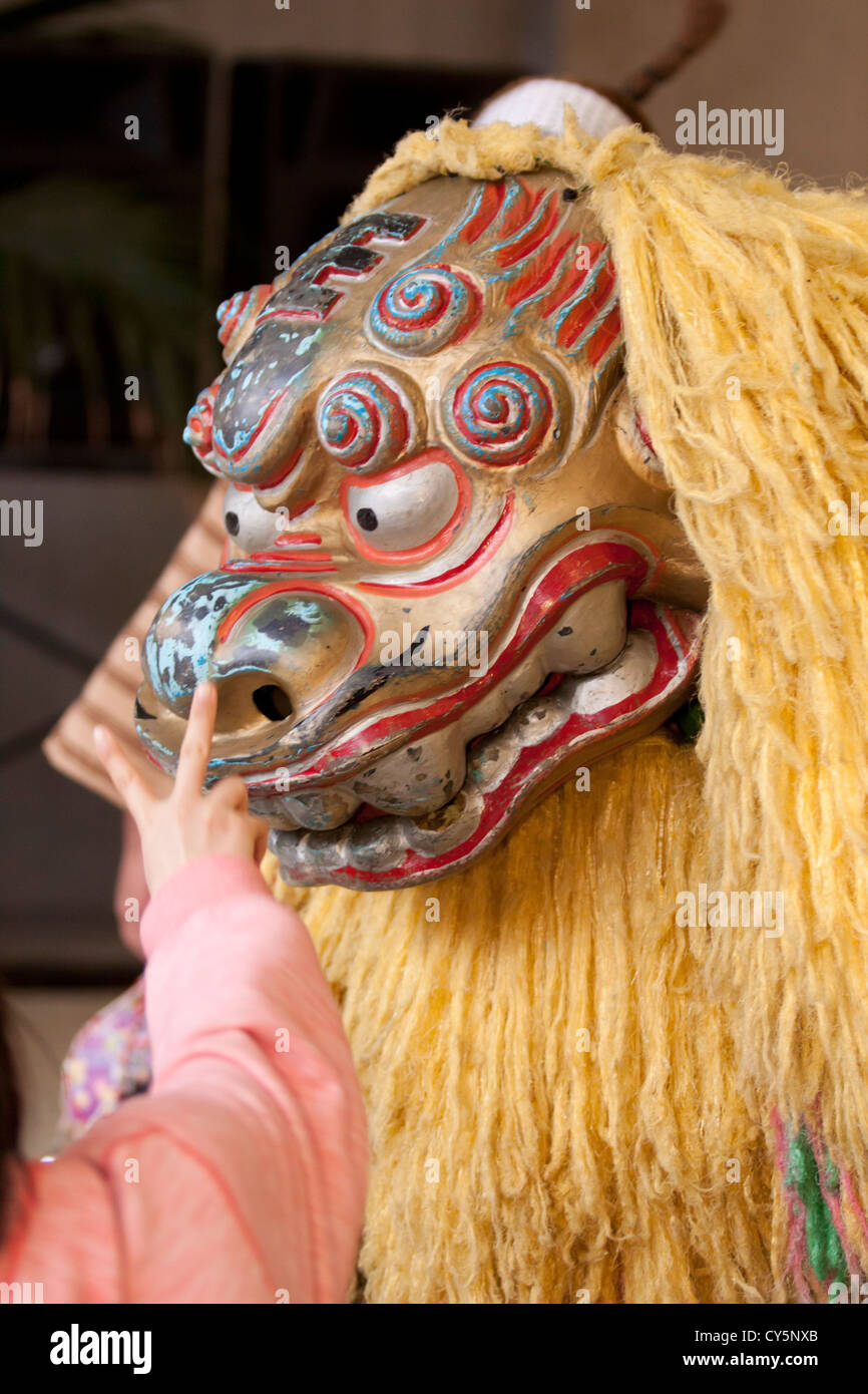 A lion god - Shiisa performs for visitors to Ryukyu Mura - a theme park ...