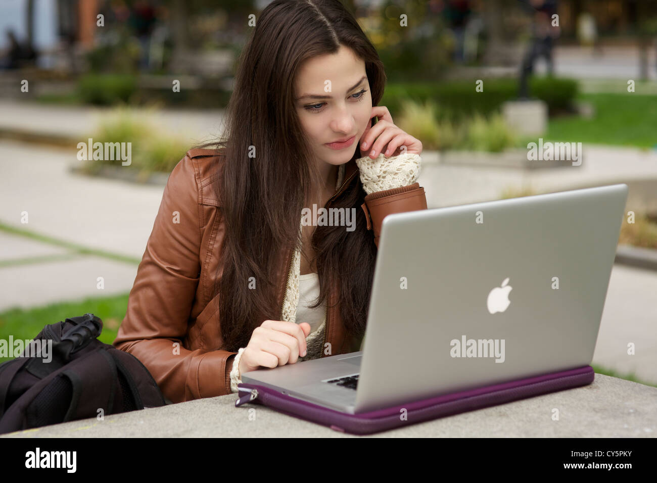 Beautiful young woman using laptop outdoor Stock Photo - Alamy