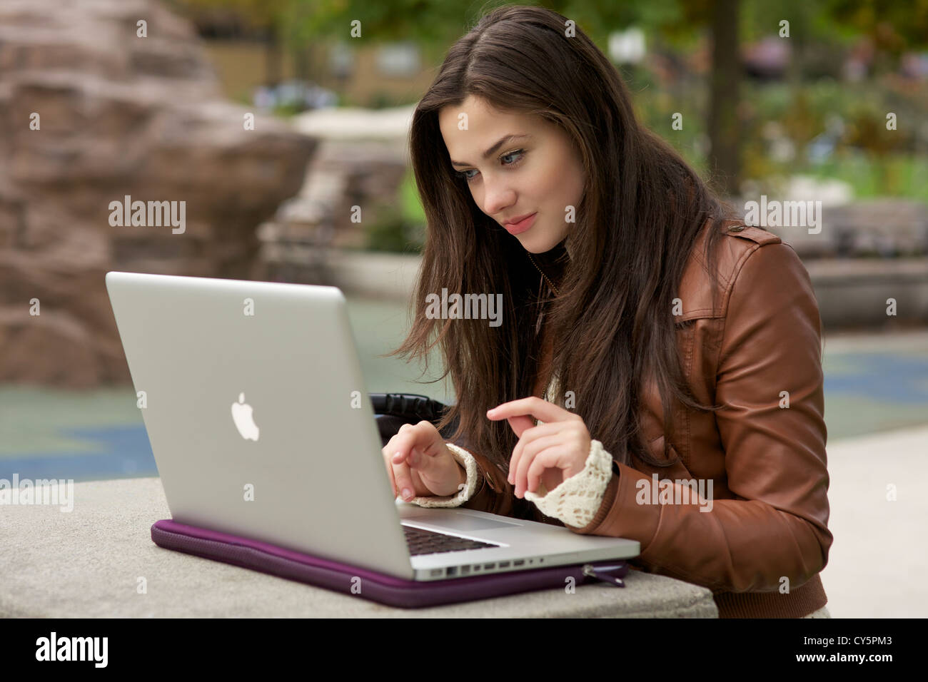 Beautiful young woman using laptop outdoor Stock Photo - Alamy