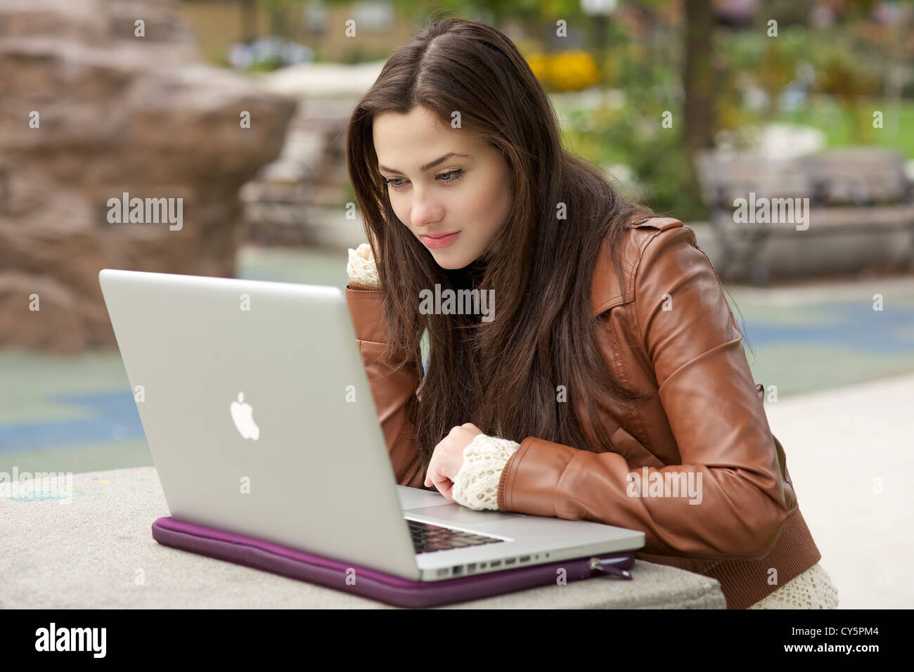 Beautiful young woman using laptop outdoor Stock Photo - Alamy