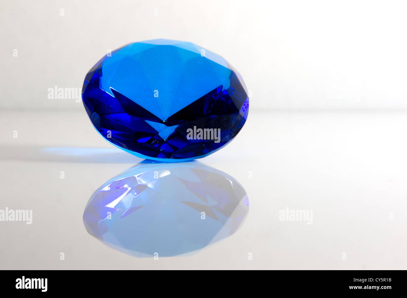 Faceted round cut blue gemstone on white background Stock Photo - Alamy
