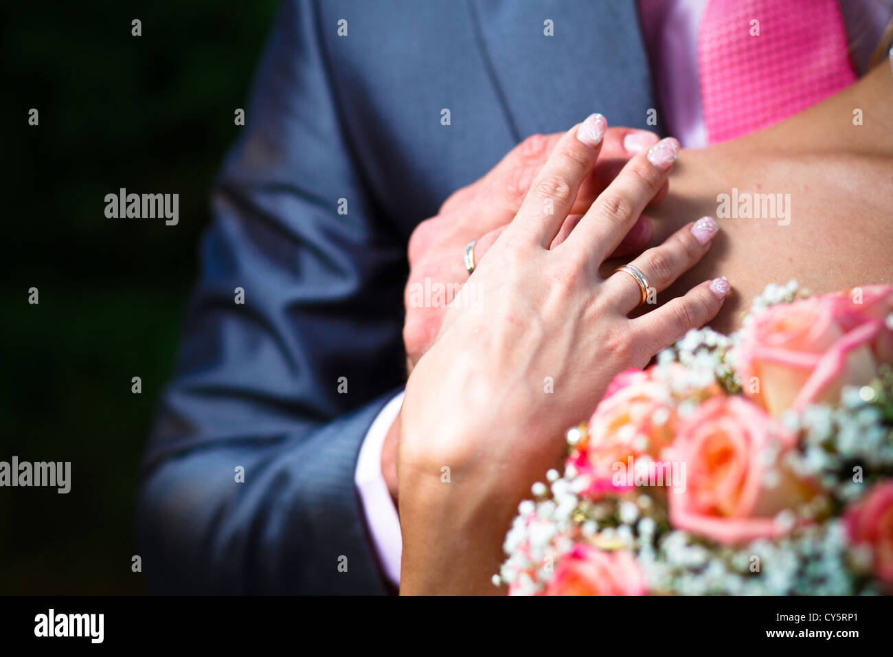 Hands with wedding ring on brides shoulder Stock Photo - Alamy