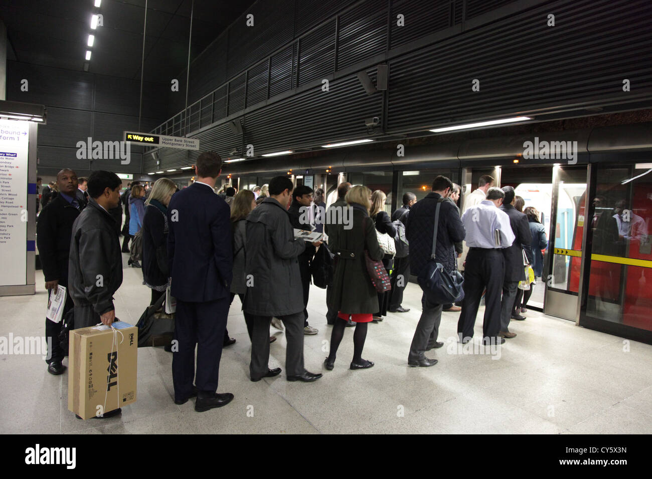 Tube commuters queue to get on the Underground at Canary Wharf Station ...