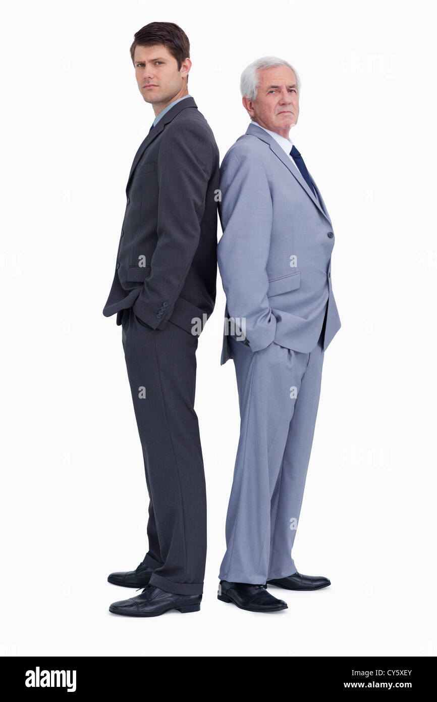 Serious businessmen standing back to back Stock Photo - Alamy