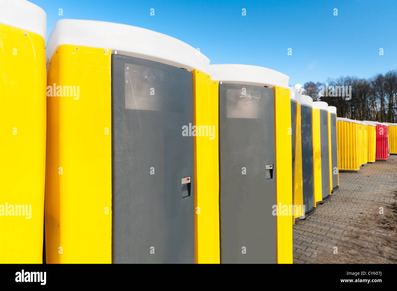 yellow portable toilets under a nice cloudy sky Stock Photo - Alamy