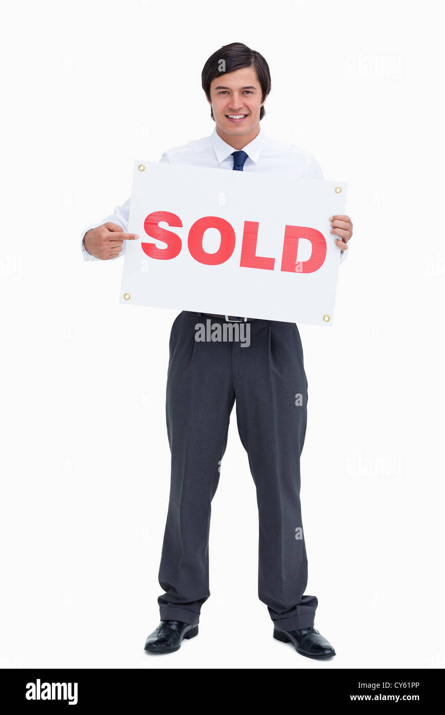 Smiling male real estate agent pointing at sold sign Stock Photo - Alamy
