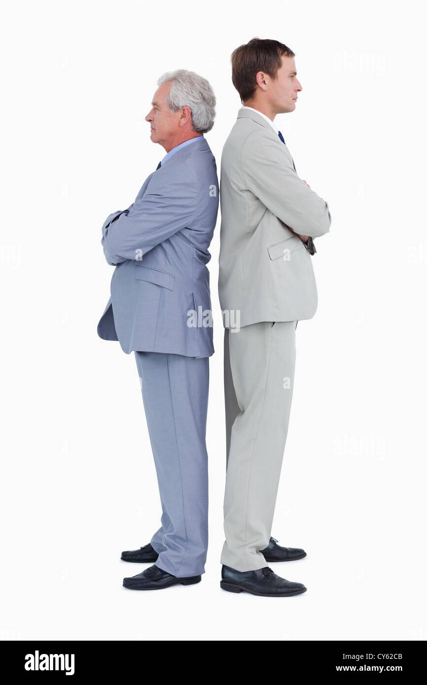 Side view of serious tradesmen standing back to back Stock Photo - Alamy